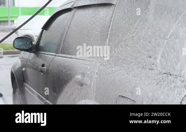 A man washes a black car covers car with soapy foam. Slow Motion Video ...