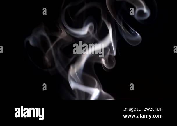 Smoke streaming in the dark from a burning incense stick. Whimsical ...