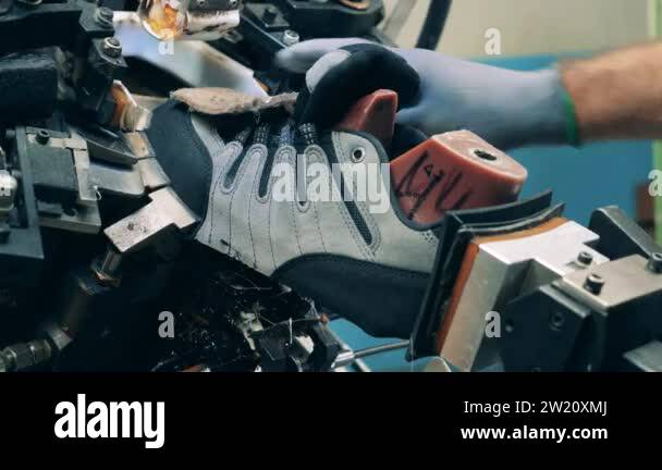 Industrial machine is being used to shape a boot. Factory production of ...