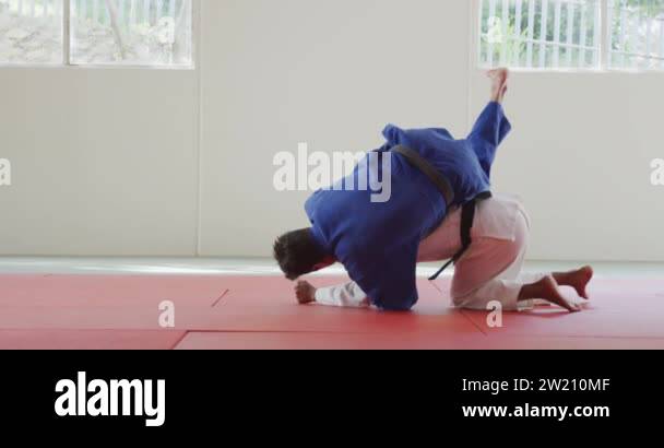Side view of a mixed race male judo coach and teenage mixed race male ...