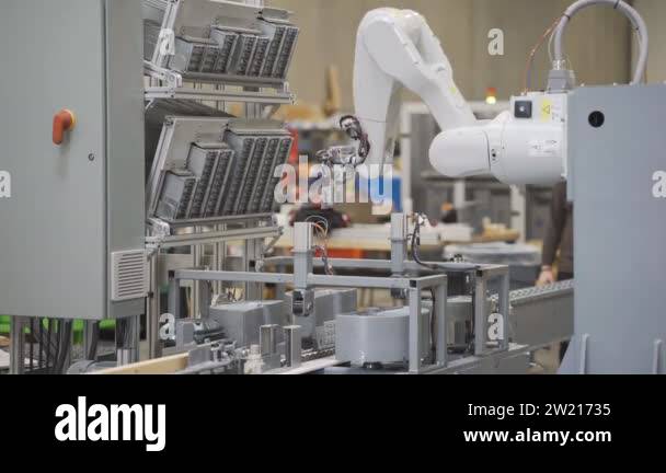 Automated machine in Industrial factory. Advanced robots placing parts in an automated assembly ...