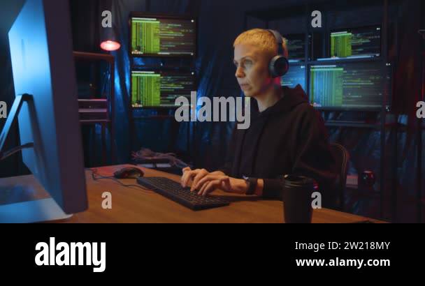 Caucasian woman hacker with blond short hair in headphones sitting in ...