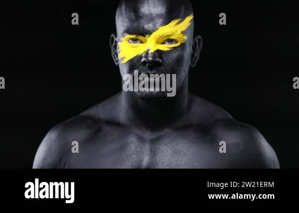 Man sports fan and bodybuilder athlete with yellow color on face art ...