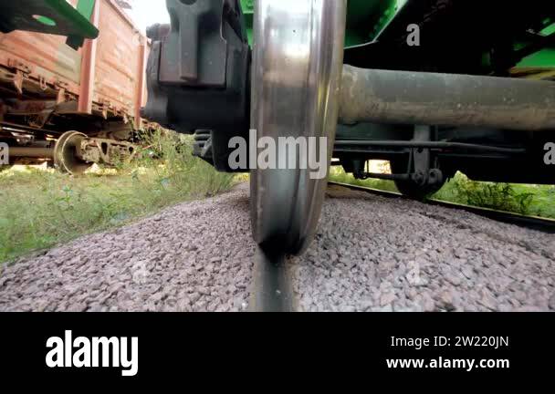 4k dolly video of looking underneath heavy cargo train car on station ...