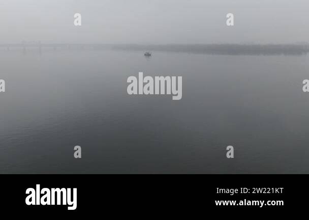 A barge loaded with scrap metal and waste floating on a water surface ...