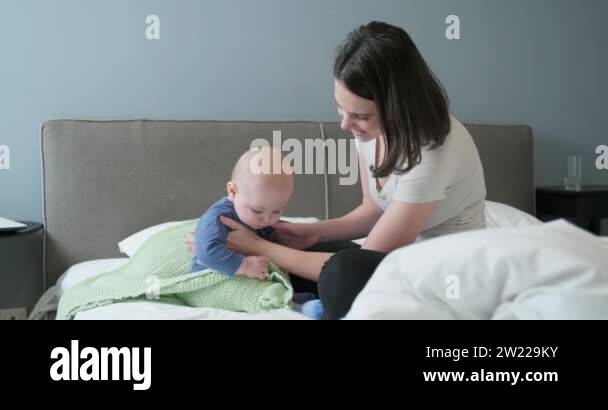 Caring for infant, mother raising son in arms hugging and kissing Stock ...