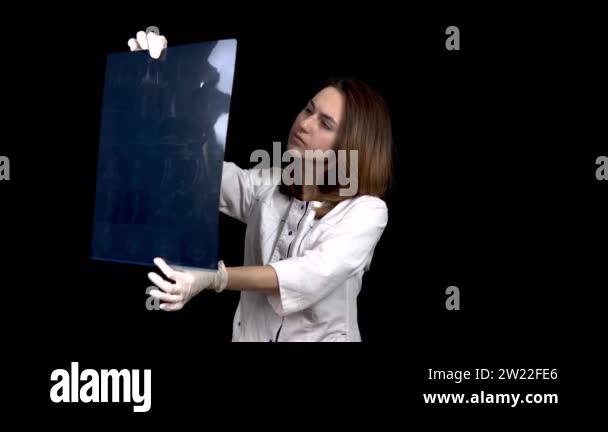A young woman doctor checks the results of an MRI scan of a spine. A ...