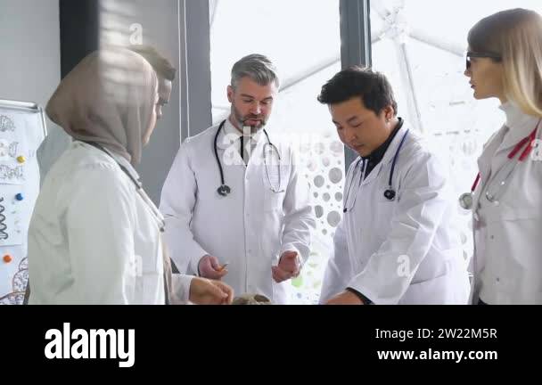 Four concentrated mixed race doctors-interns which working together during the lecture about the ...