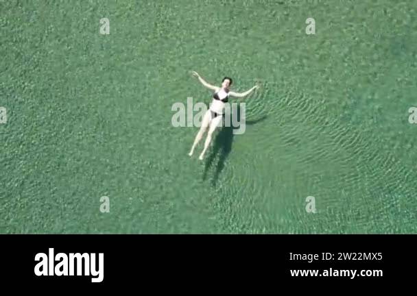 Woman enjoying vacation, floating in bikini on surface of sea in the ...