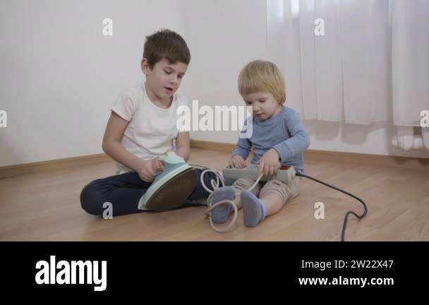 curious children play with dangerous objects, little brothers studying ...