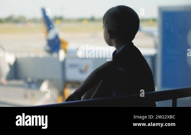 Silhouette video of little sad boy sitting next to big window in ...