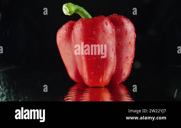 Closeup slow motion video of water droplets falling on red bell pepper ...