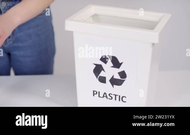 Container for recycling waste sorting plastic in selective focus and unrecognizable hands ...