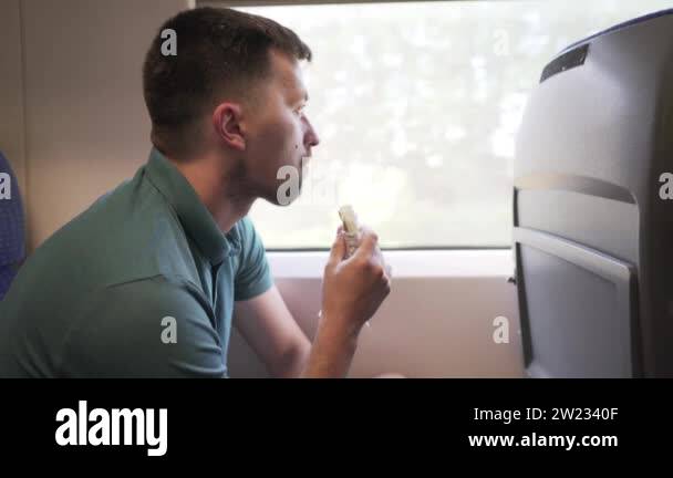 Caucasian male traveler travels in a passenger high-speed train at the ...