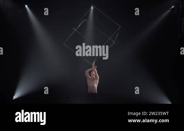 circus male muscular performer making tricks with juggling cube props ...
