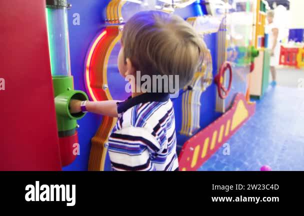 4k video of little boy putting plastic balls in pneumatic mechanism in ...