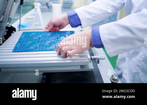 the worker takes the motherboard and transfers it to the conveyor line ...