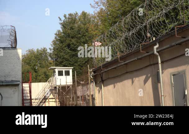 Coils of Barbed Wire on Top of a Fence. Jail Cells. Prison Interior ...