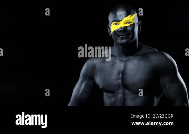 Man sports fan and bodybuilder athlete with yellow color on face art ...