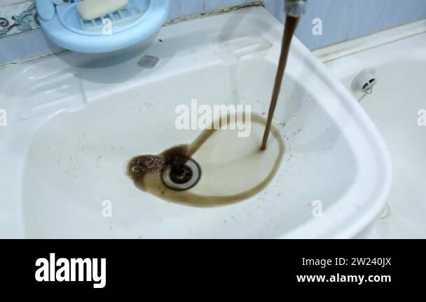 rusty and dirty water flows from the faucet into the sink. Purification ...
