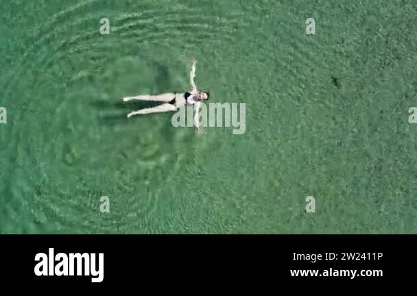 Woman enjoying vacation, floating in bikini on surface of sea in the ...