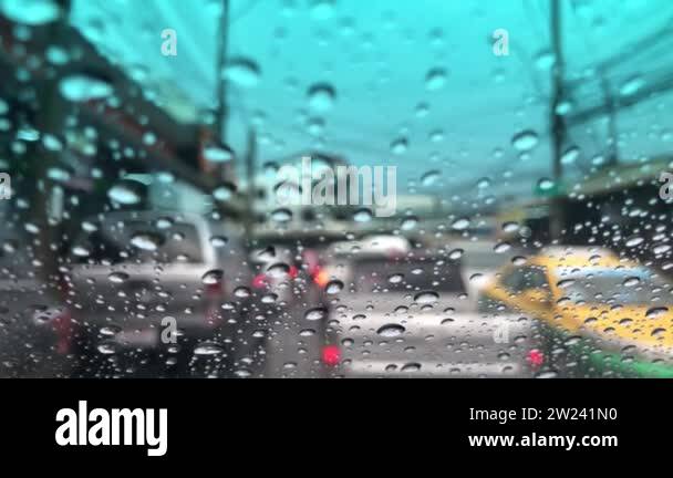 Defocused image of raindrop on car windshield,blurred traffic on the ...