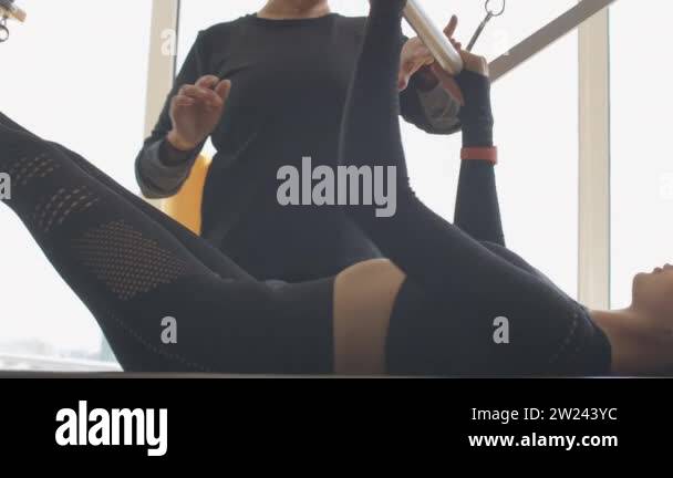 Live camera follows hands of young athletic woman training on pilates ...