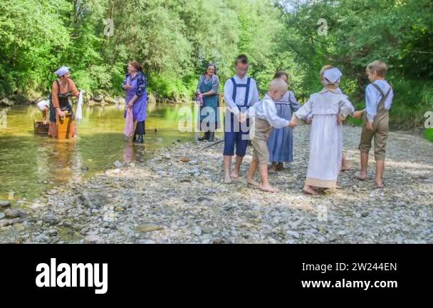 Two different worlds: older women and young children. Women are washing ...