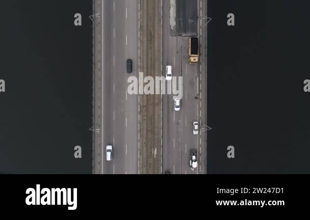 Cars ride on two bridges over the river. The camera is directed ...