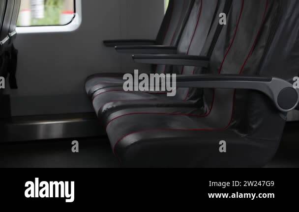 An empty row of seats on a new commuter train. Interior with gray ...