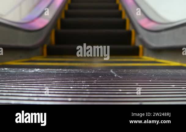 Low angle looped perspective view of modern escalator stairs. Automated ...