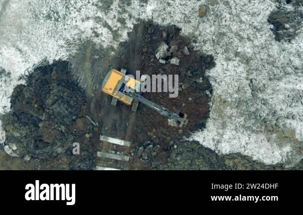 Excavator digging soil at a construction site. Top view of an ...