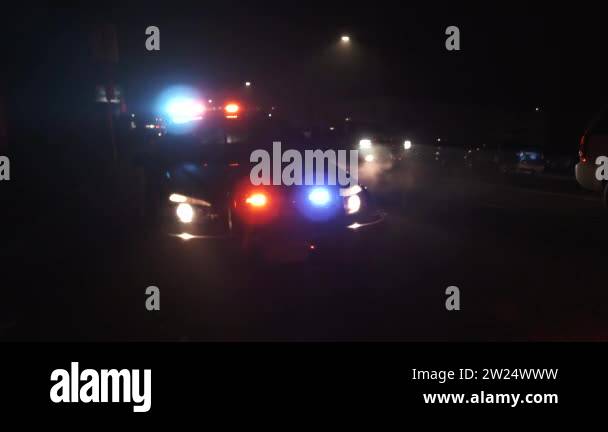 Police car parked on side of road with flashing lights establishes a ...