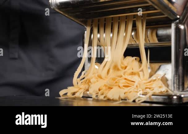 Traditional italian homemade pasta being made on machine for cutting ...