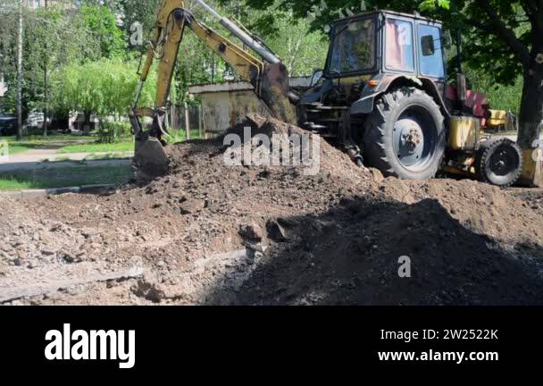 Tractor pits the ground. Backhoe piles up the ground close-up Stock ...