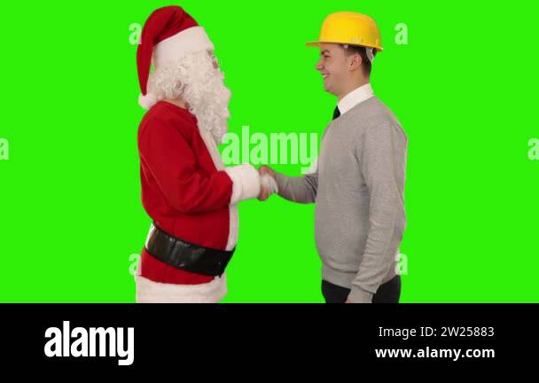 Santa Claus and Young Architect shaking hands and looking at camera ...