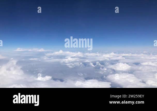 Stunning footage of aerial view above clouds from airplane window with ...