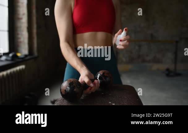 Girl cleaning of sport equipments of gym with disinfecting spray. Woman ...