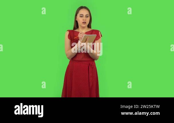 Tender girl in red dress is standing and thinking, then happy writing ...