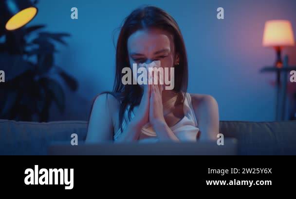 Sad young woman worrying while watching an emotional scene in movie ...