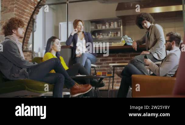 Colleagues and clients talking strategy in dining area.Group of ...