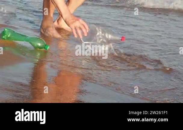 Man collects plastic bottles from the black sea. Paradise beach ...
