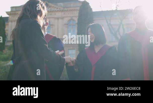 Rear of the young pretty Caucasian female prfessor giving diplomas to ...