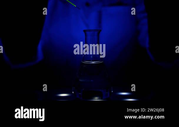 A scientist is mixing different color solution on a magnetic stirrer UV ...