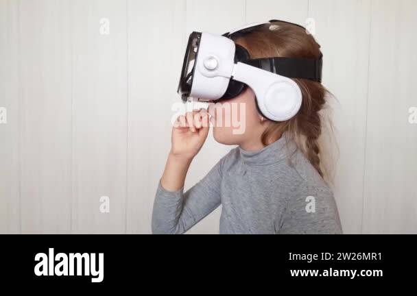 Teenager girl playing using VR glasses. Beautiful young girl wearing virtual reality headset ...