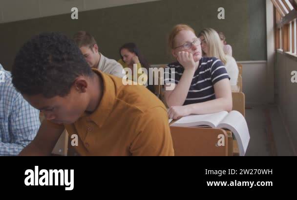 Front view of a teenage Caucasian girl in a school classroom sitting a ...