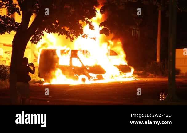 A car is burning and gasoline is dripping and burning. Unrecognizable ...