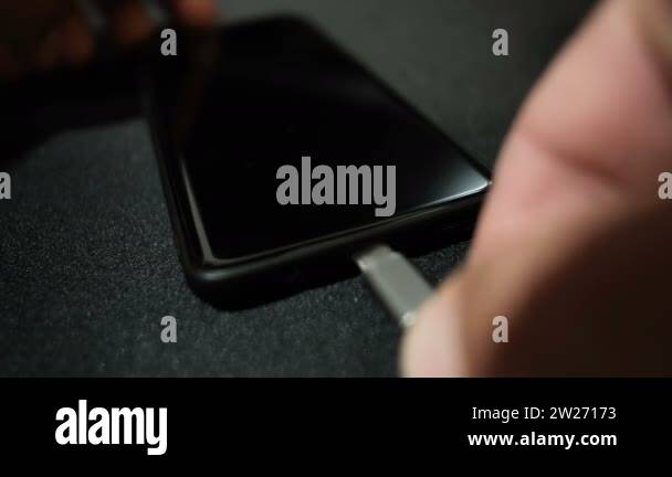 Close up view of man hand while charging smartphone using usb c ...