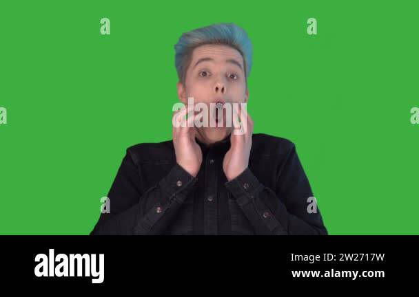 Amazed young man shocked, saying WOW. Guy surprised to camera on green ...