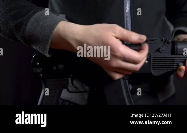 The bandit reloaded the AK-47 assault rifle on a black background ...